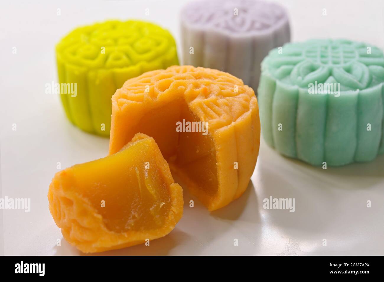 An orange mini snow skin mooncake with cut wedge & mango paste filling ...