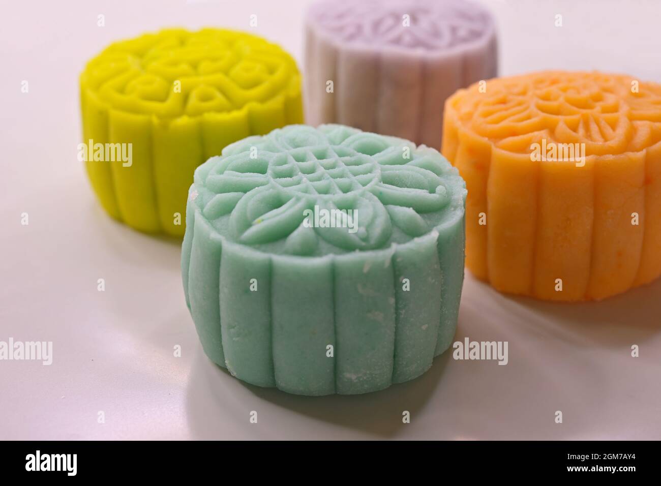Close-up of four mini snow skin mooncakes with floral imprints on white ...