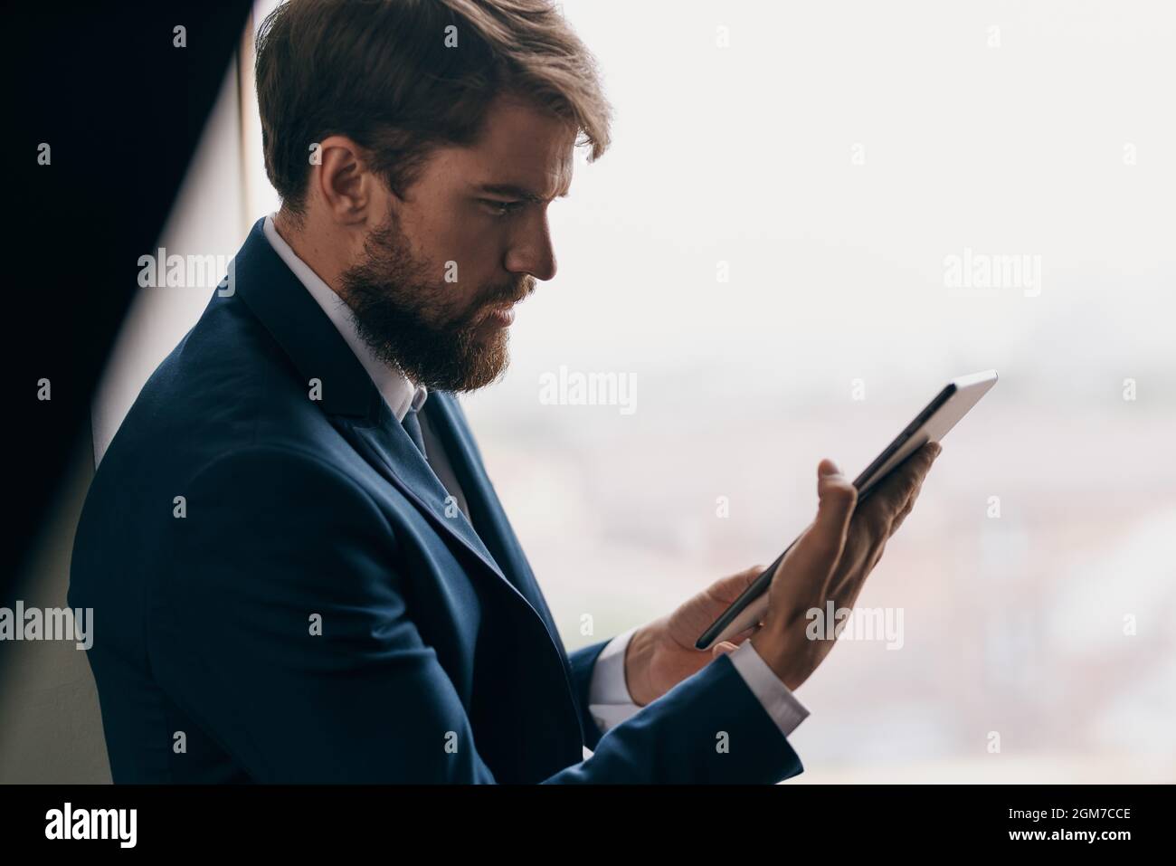 business man near window with tablet in hands communication technology ...