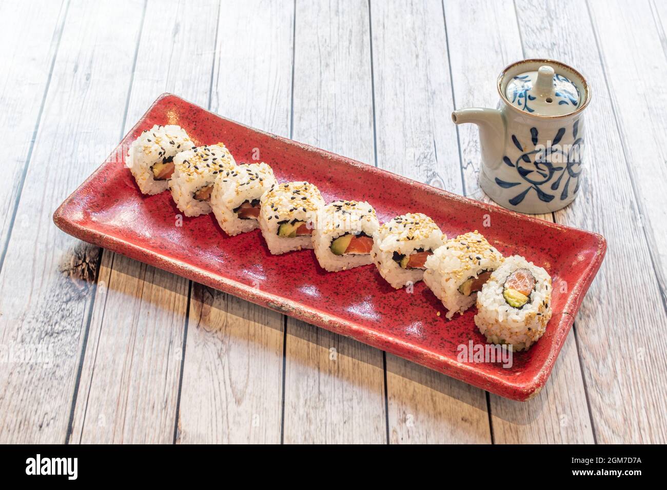 Uramaki sushi stuffed with nori seaweed, cheese, marinated salmon, ripe ...