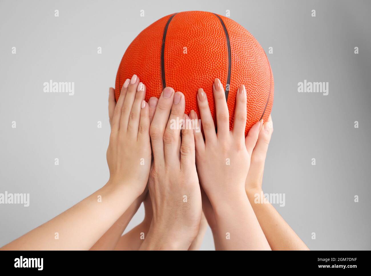 People holding ball together on grey background. Unity concept Stock ...