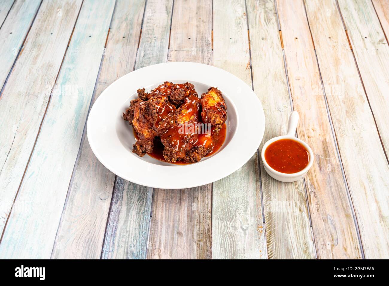 serving of chicken wings in barbecue sauce inside a restaurant's white ...