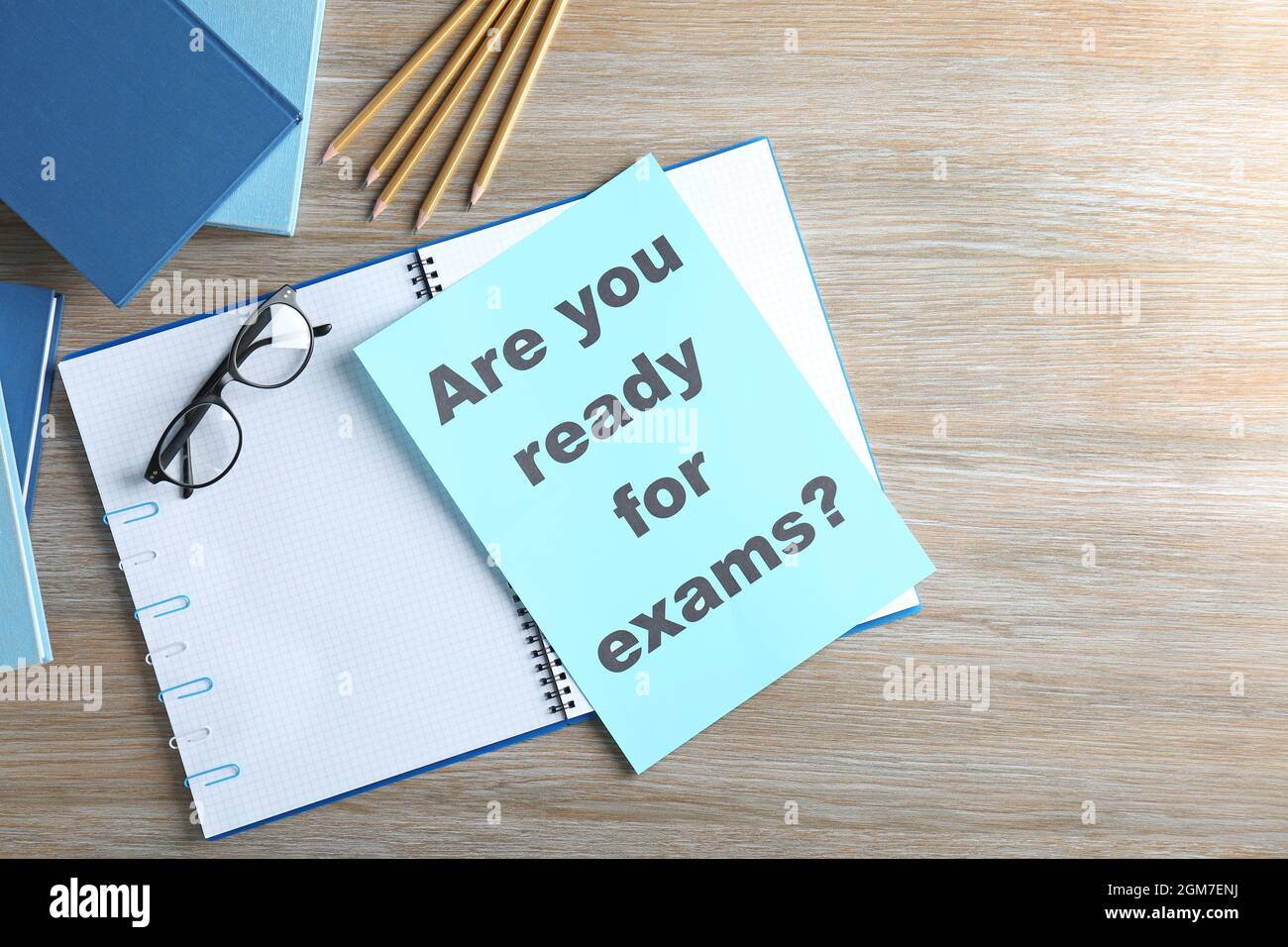 Paper with question "Are you ready for exams?" and notebook on table ...