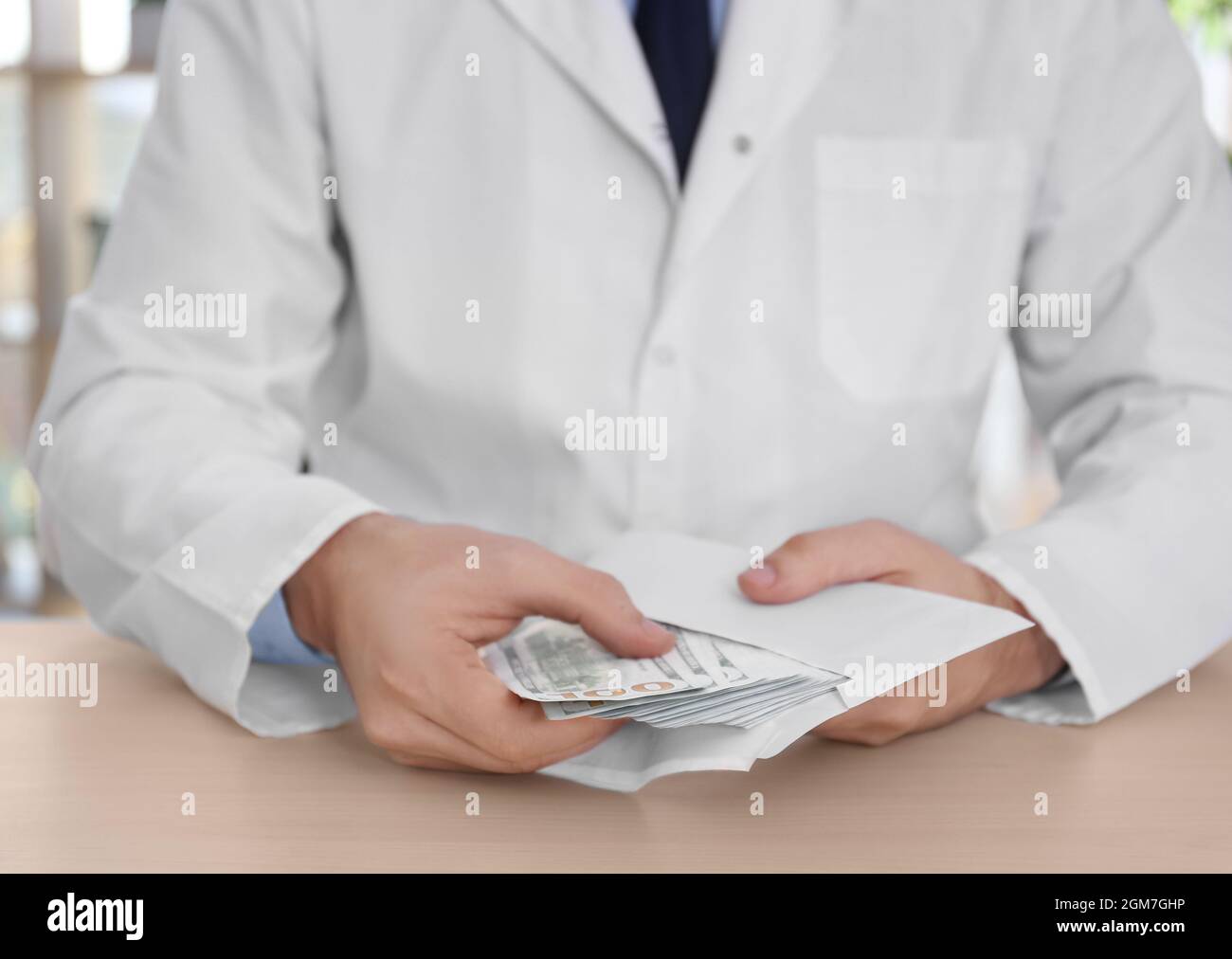 Male doctor with bribe at workplace, closeup Stock Photo - Alamy