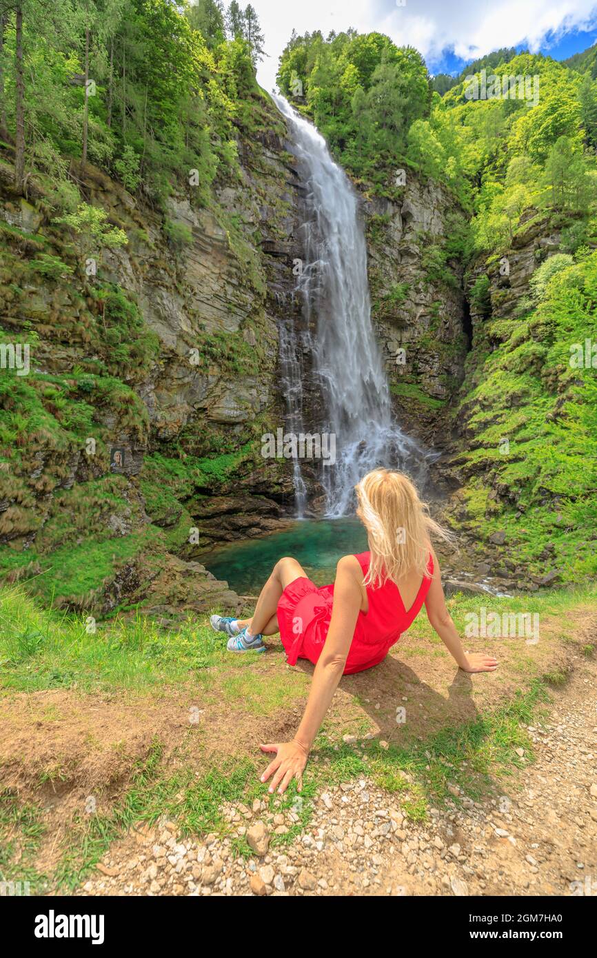 Woman sitting by the Froda waterfall or Sonogno waterfall over the ...