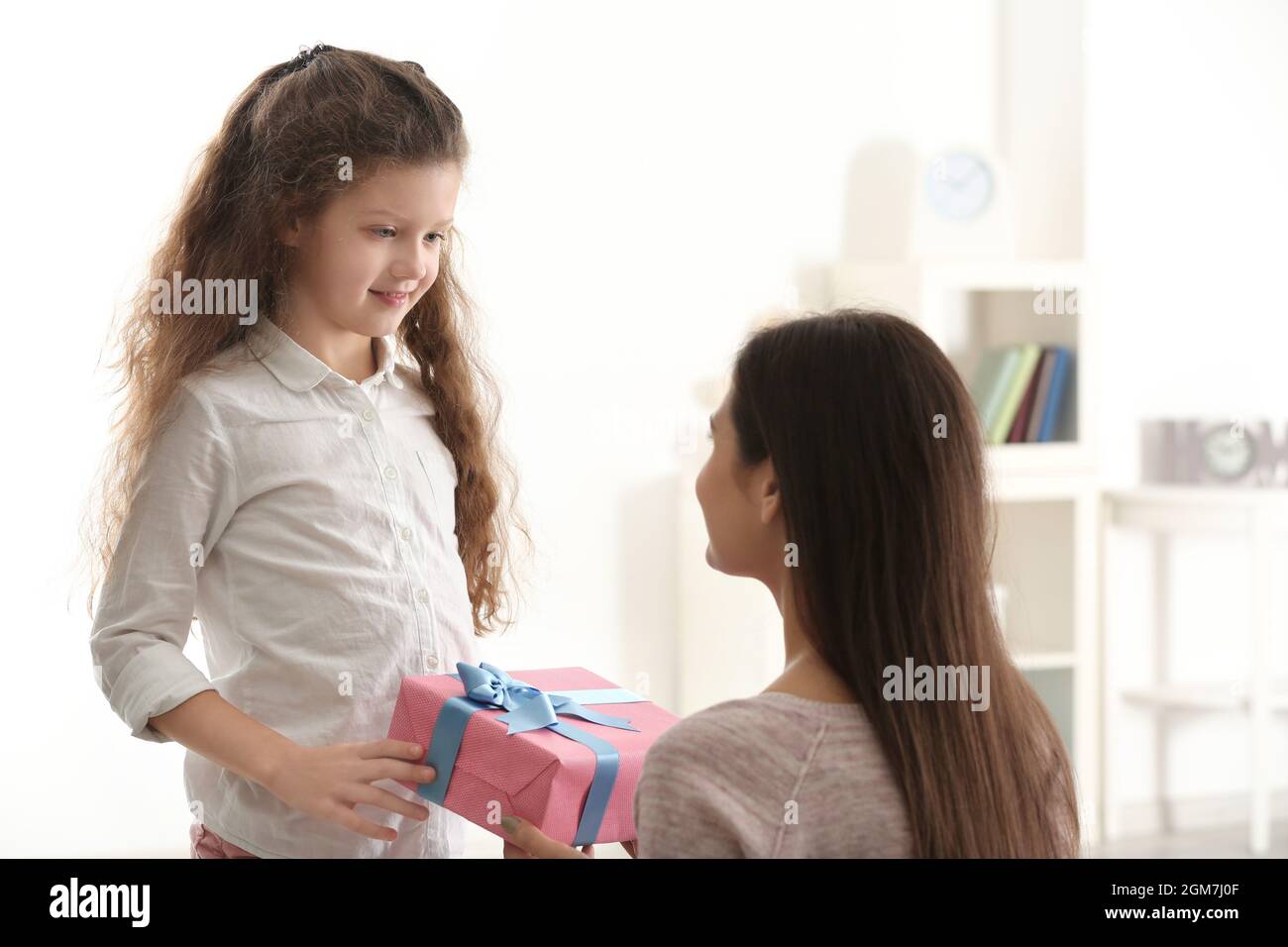 Cute little girl giving gift box to her mom indoors. Mother's day celebration Stock Photo - Alamy