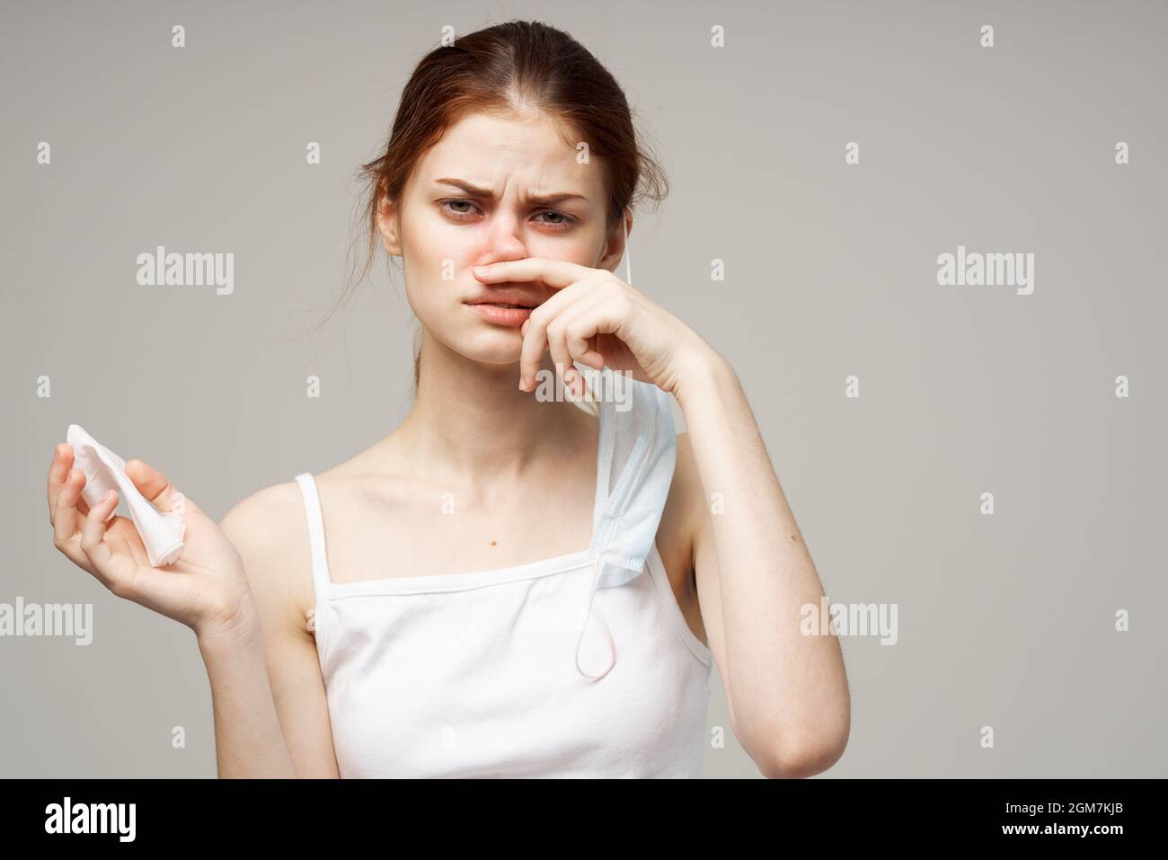 sick woman in white t-shirt with a scarf light background Stock Photo ...