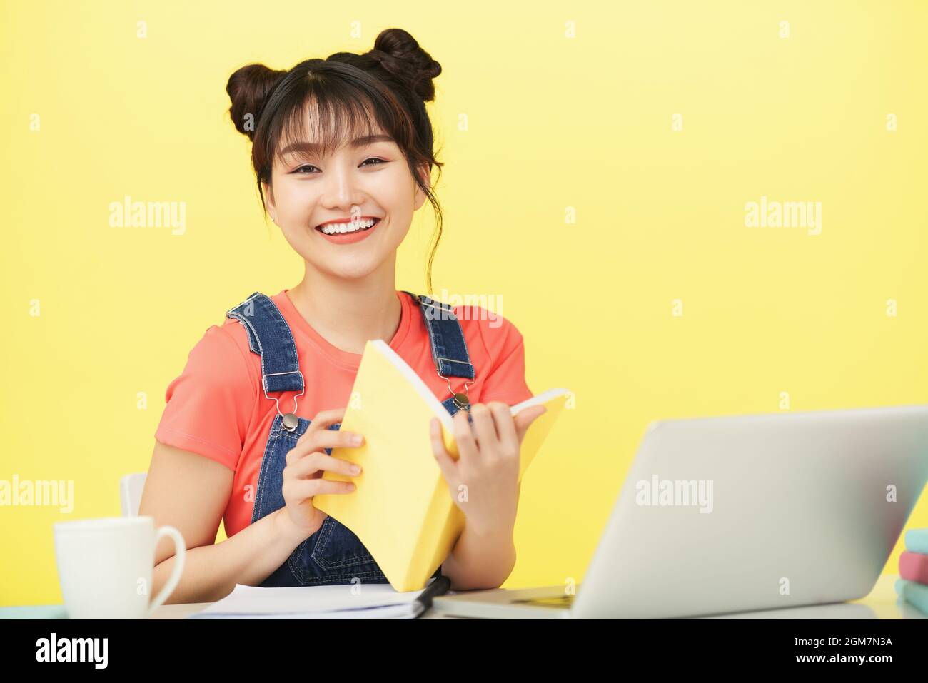 Portrait of happy laughing young college student reading book and ...
