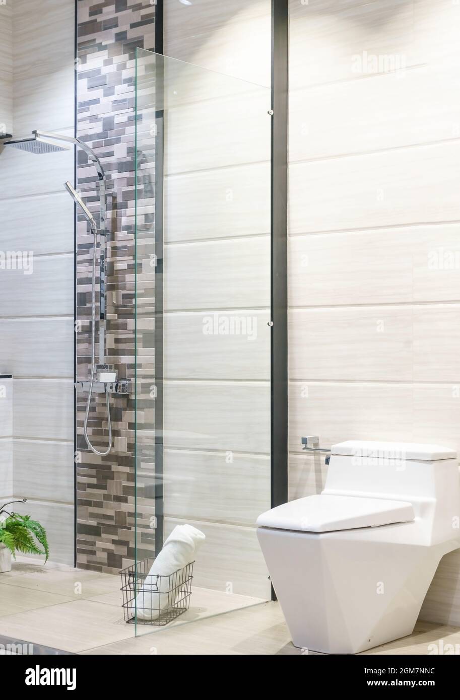 Modern spacious bathroom with bright tiles with glass shower, toilet ...