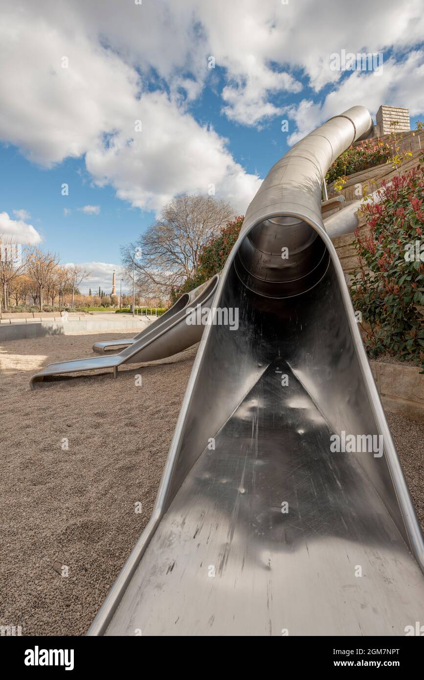 Stainless steel slide in a park in the center of Madrid with gravel ...