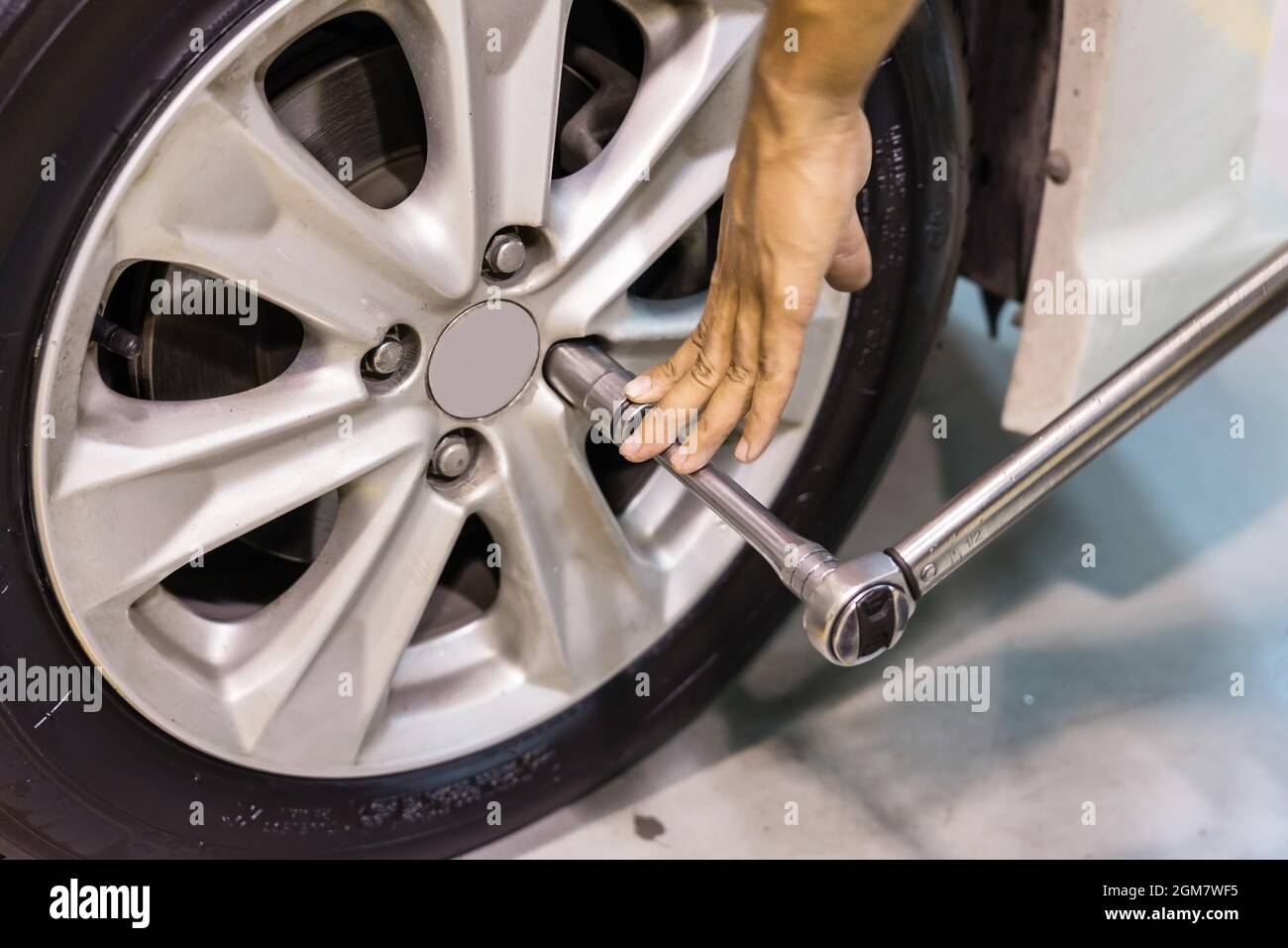 Professional car mechanic changing car wheel in auto repair service ...