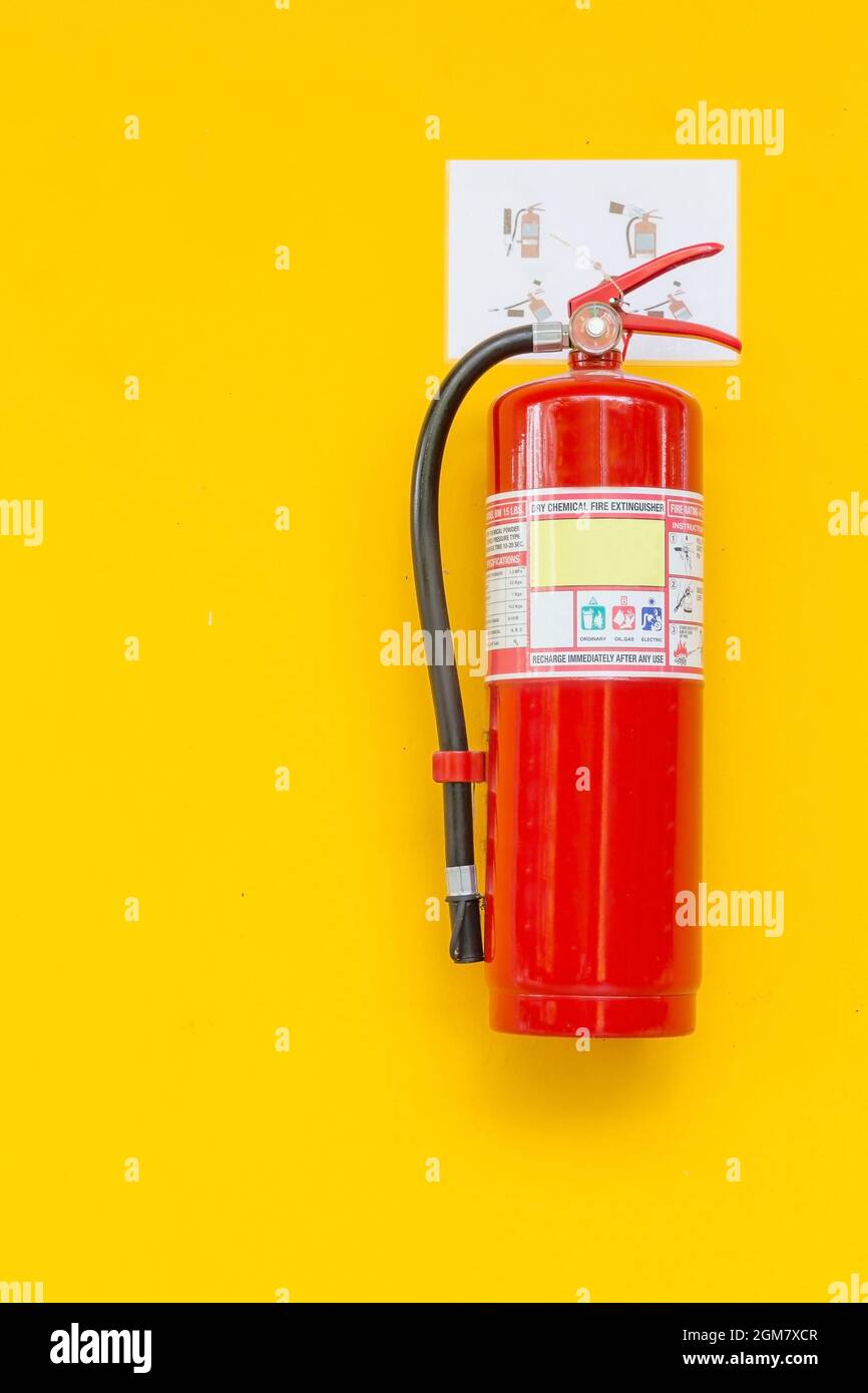 Fire extinguisher on the yellow wall Stock Photo - Alamy