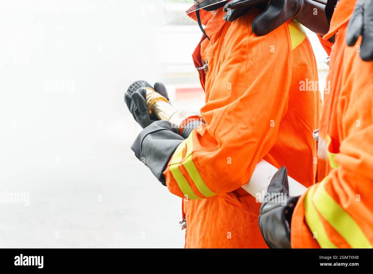 Firefighter using extinguisher and water from hose for fire fighting ...