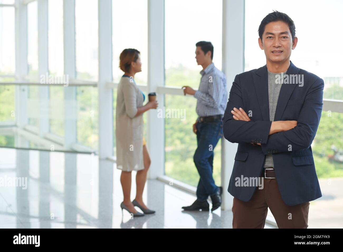Leadership standing communication place of work arms crossed hi-res ...