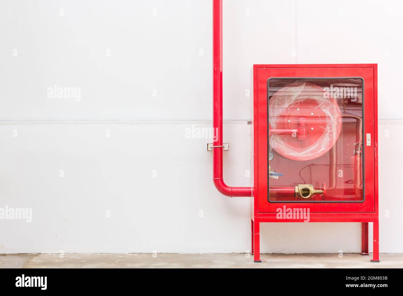 Red fire hose cabinet and extinguisher on white wall in the new ...