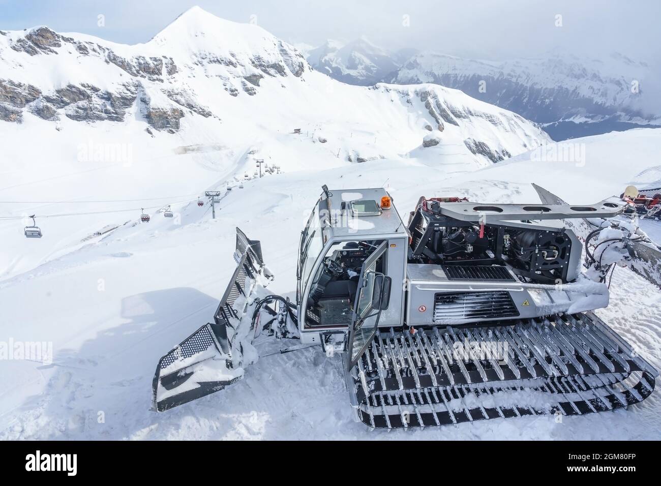 Snow-grooming machine on snow hill ready for skiing slope preparations ...