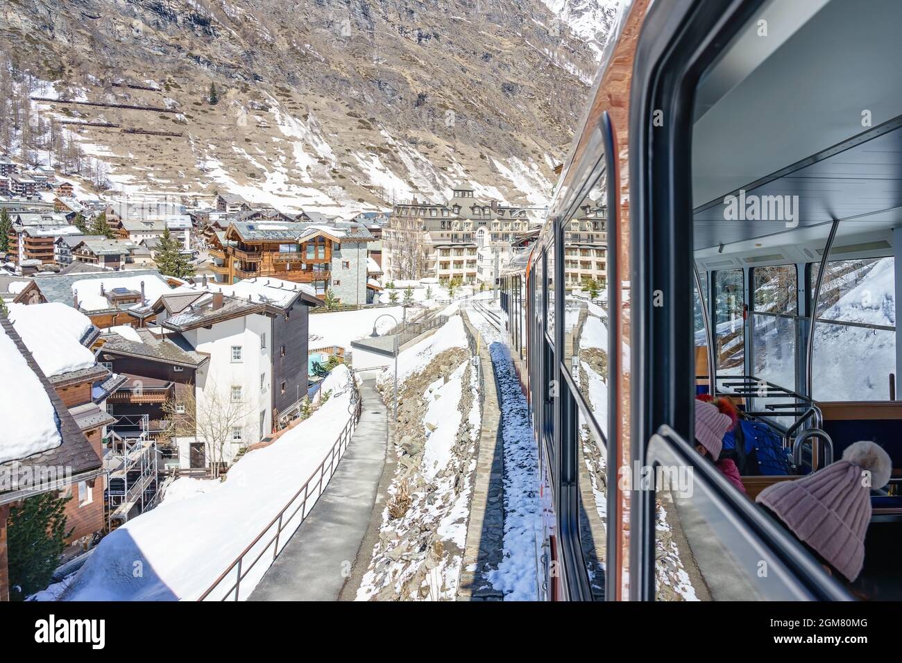 ZERMATT, SWITZERLAND - APRIL 13. 2018: Red train climbing up to ...