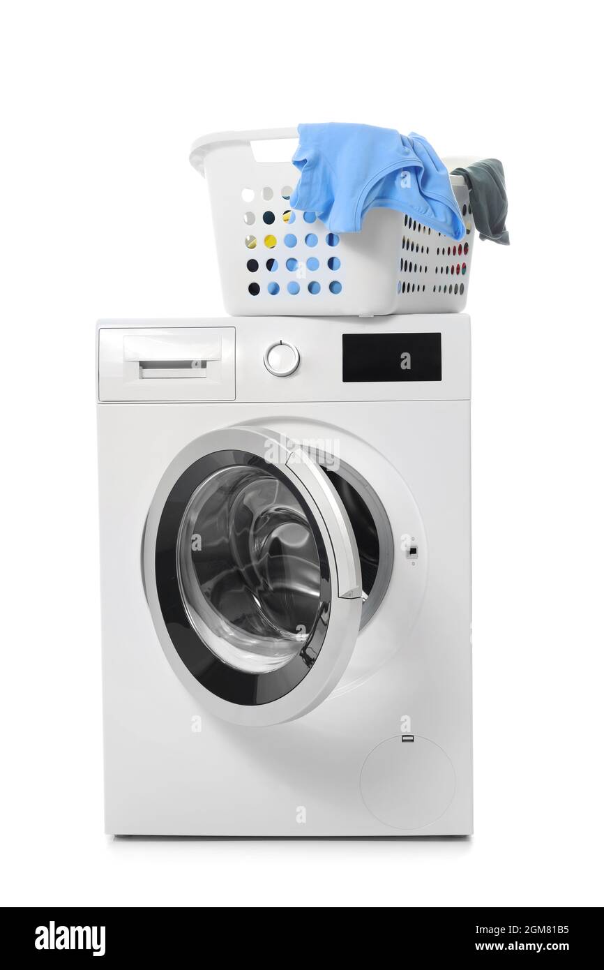 Basket with laundry on modern washing machine against white background ...