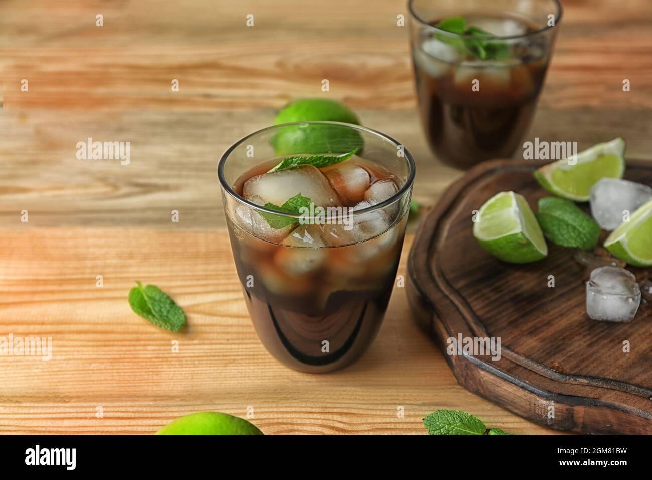 Glass of Cuba Libre cocktail on wooden background Stock Photo - Alamy