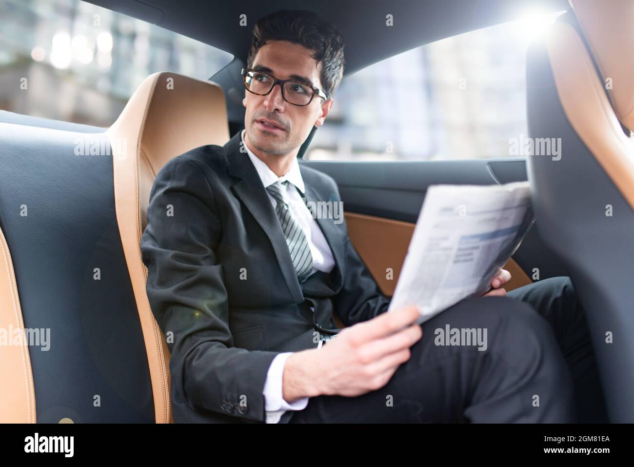 Businessman reading a newspaper in his car Lens flare effect Stock ...