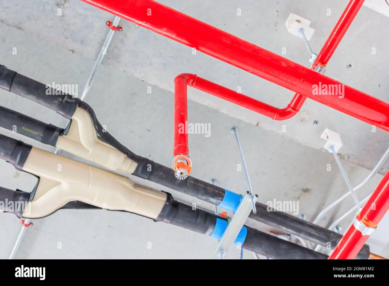 Ventilation pipes in silver insulation material and fire sprinkler on ...