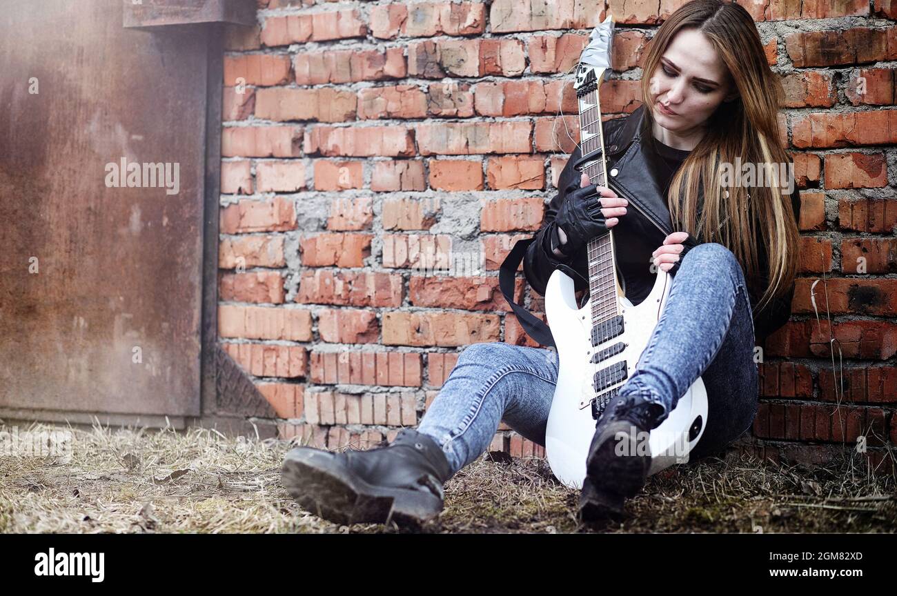 Beautiful young girl rocker with electric guitar. A rock musician girl ...