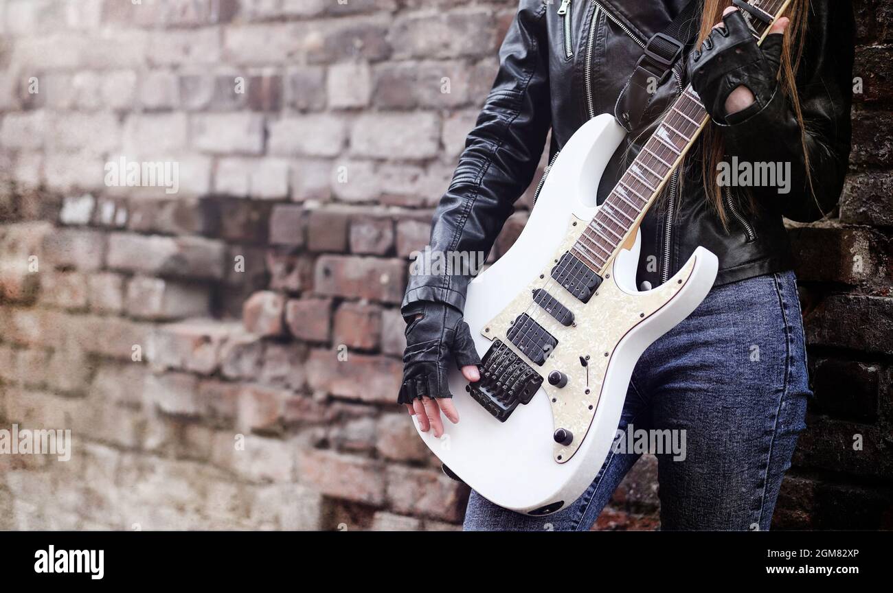 Beautiful young girl rocker with electric guitar. A rock musician girl ...