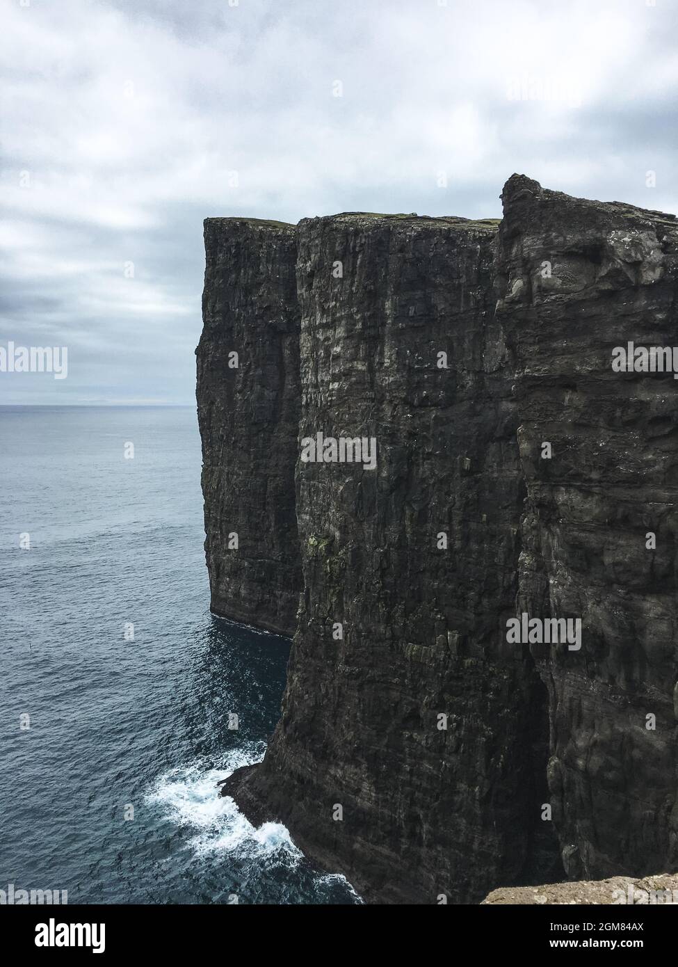 Black cliffs formation in the Atlantic ocean, Faroe Islands. Towering ...