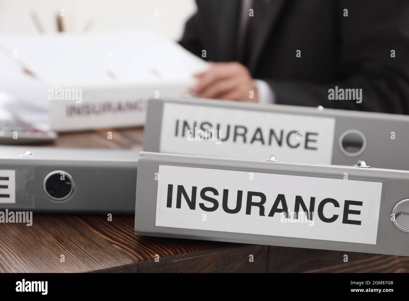 Folders with documents and man working on background. Insurance concept ...