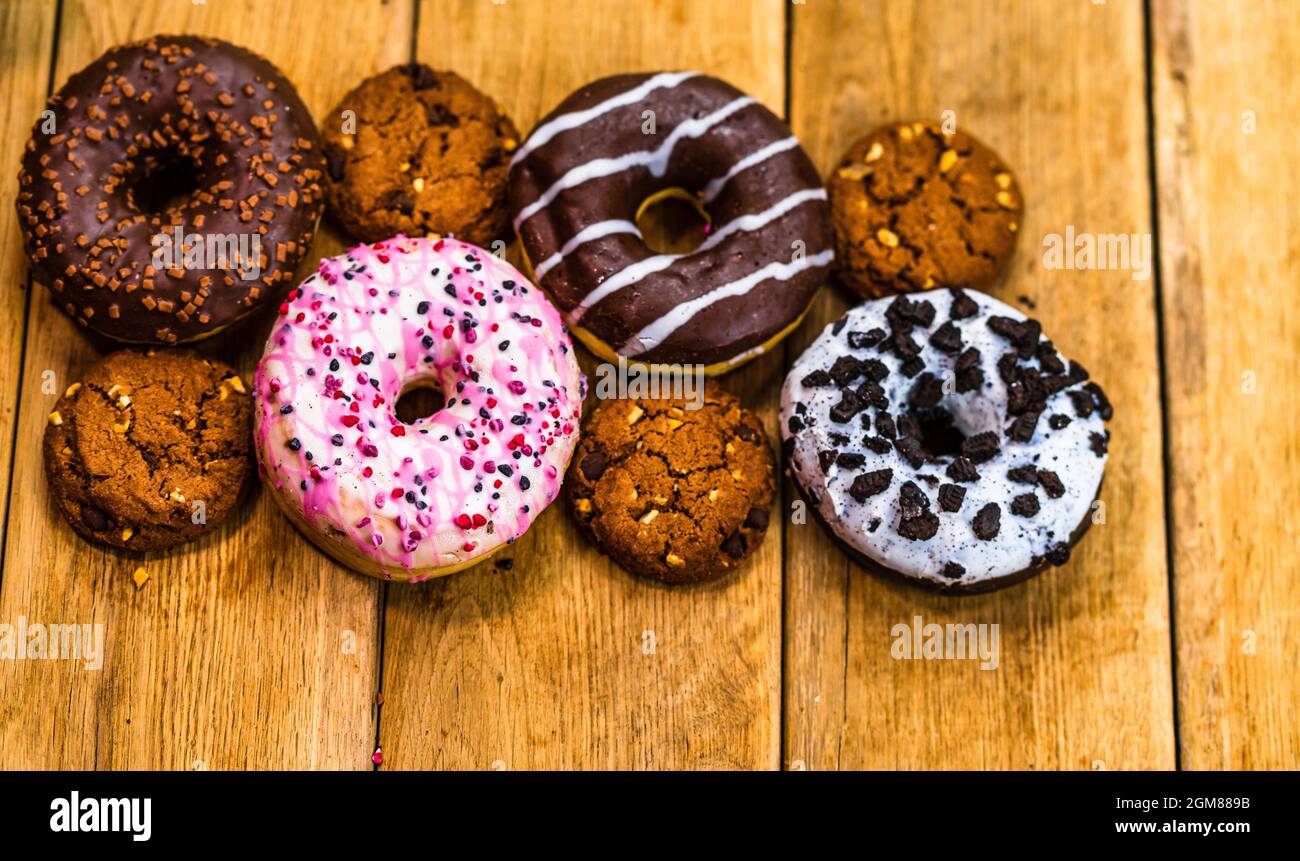 High angle shot of assorted delicious doughnuts on a wooden table Stock ...