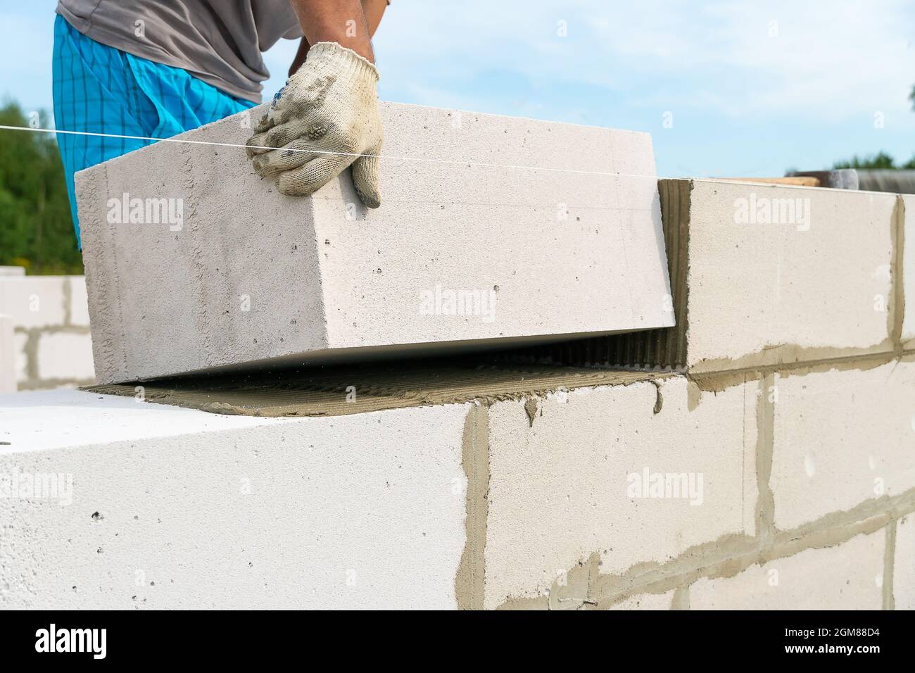 Builder makes a concrete wall with cement blocks on the construction ...