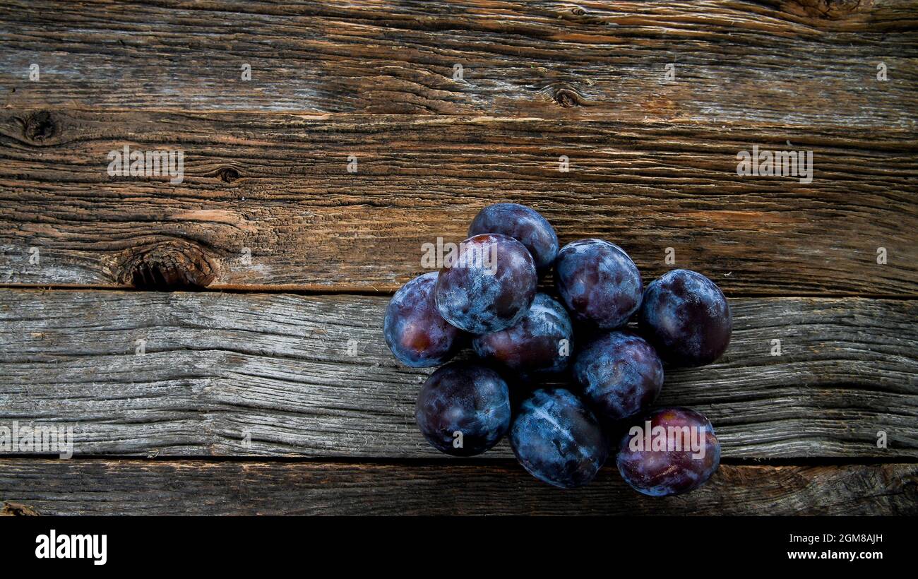 Italian plums table top on wooden background Stock Photo - Alamy