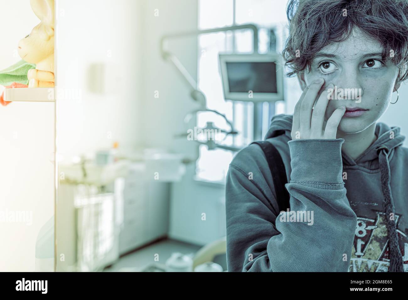 teenage girl with dark circles under her eyes and pale face looks in ...