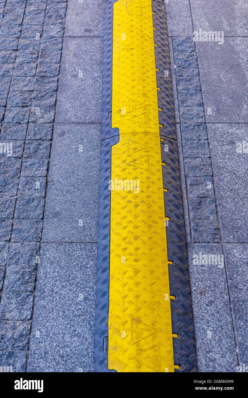Cable and Hose Protector Device at Street Pavement Stock Photo - Alamy
