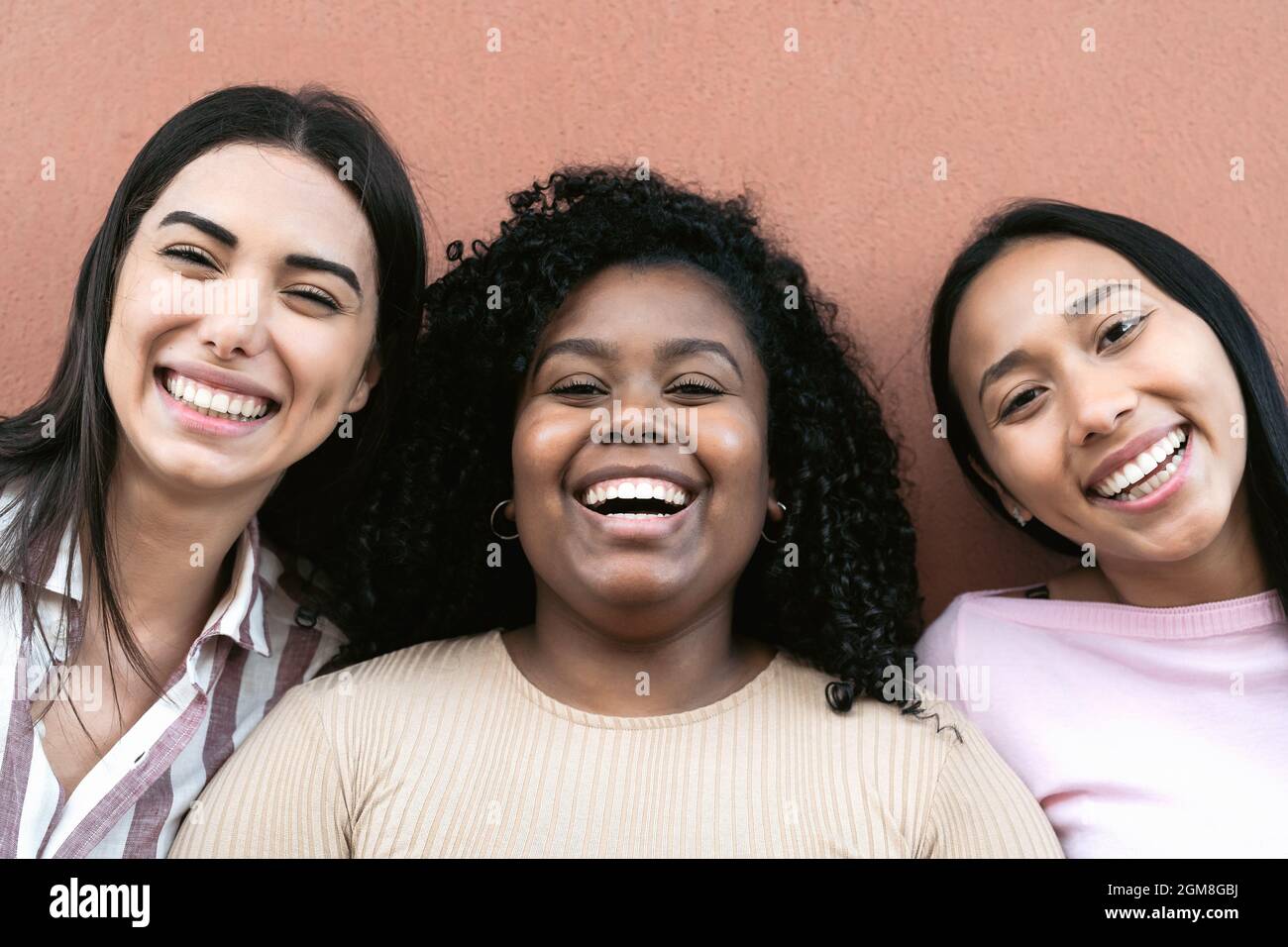 Happy multiracial friends having fun smiling together in front of ...