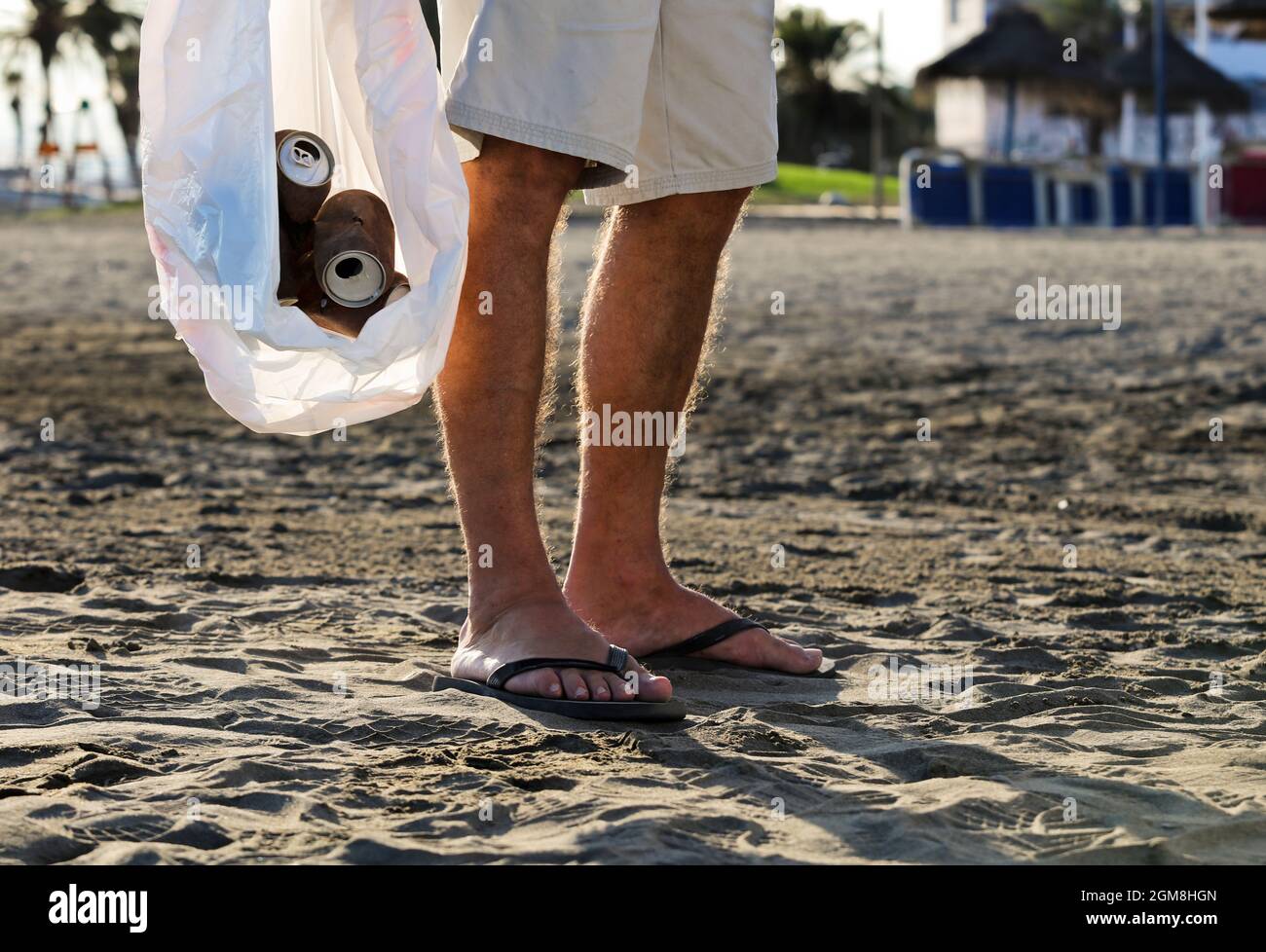 Clean the beach from trash. Man hand picking up empty trash from soda ...