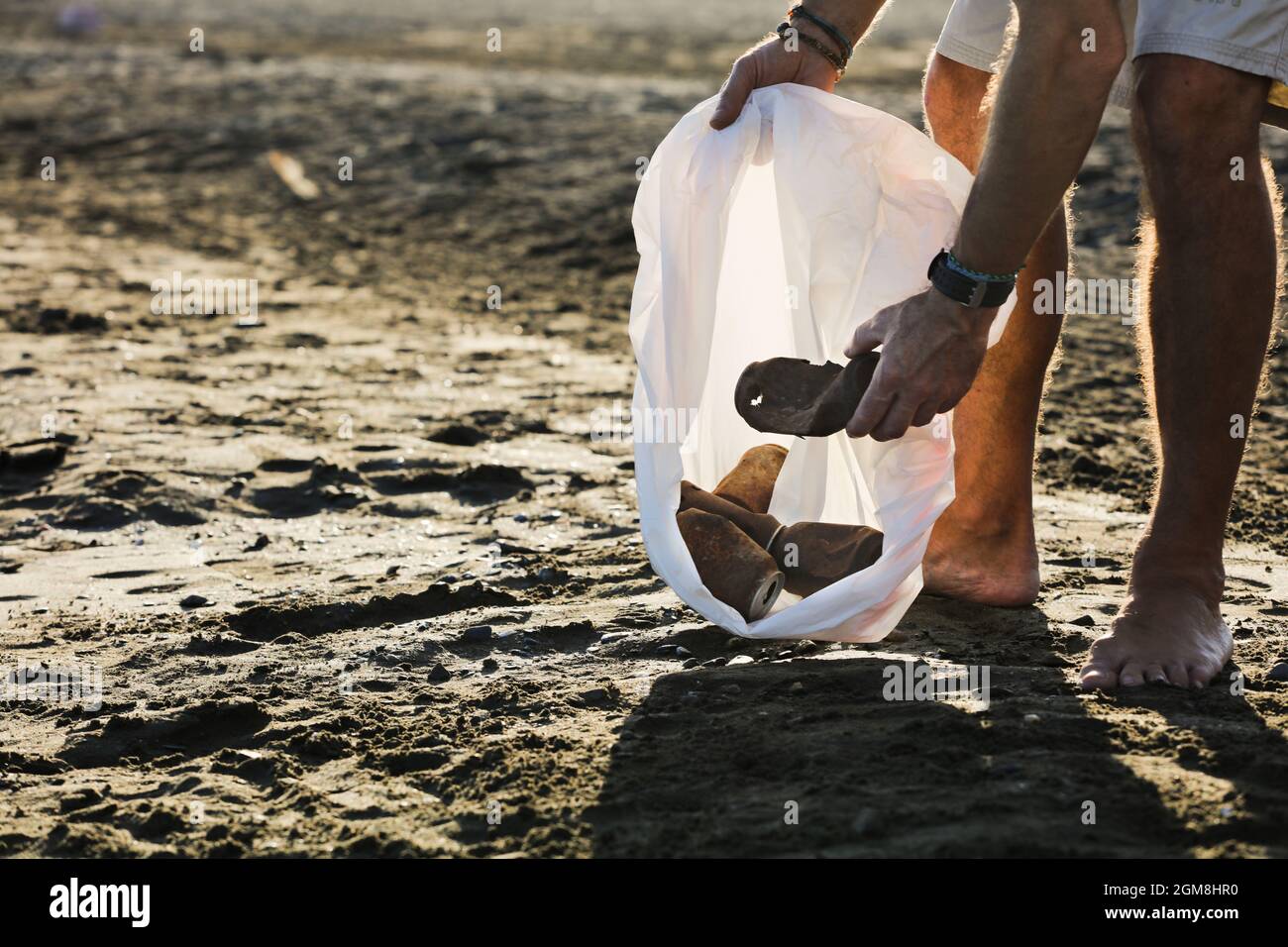 Clean the beach from trash. Man hand picking up empty trash from soda ...