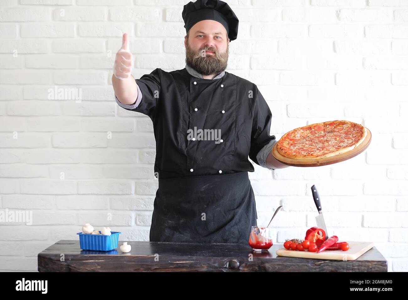 Bearded chef chef prepares meals at the table in the kitchen Stock ...