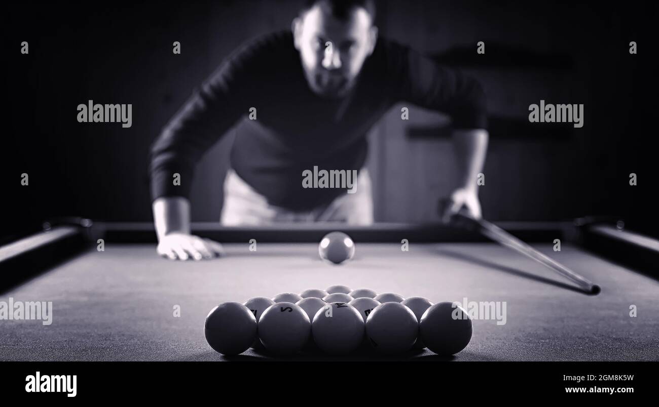 A man with a beard plays a big billiard. Party in 12-foot pool ...