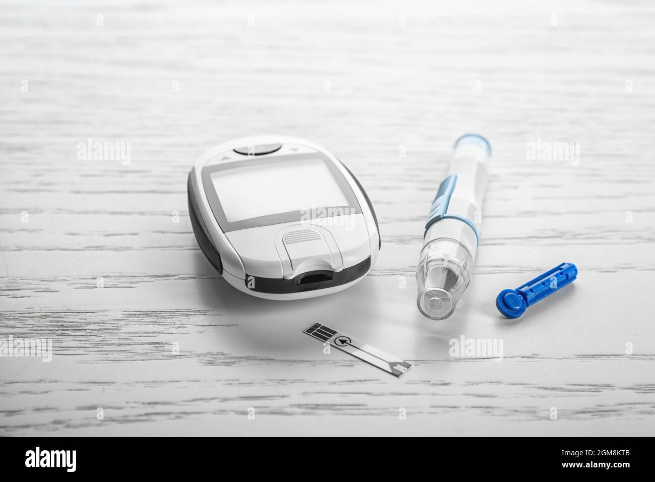 Digital glucometer and lancet pen on light background. Diabetes ...