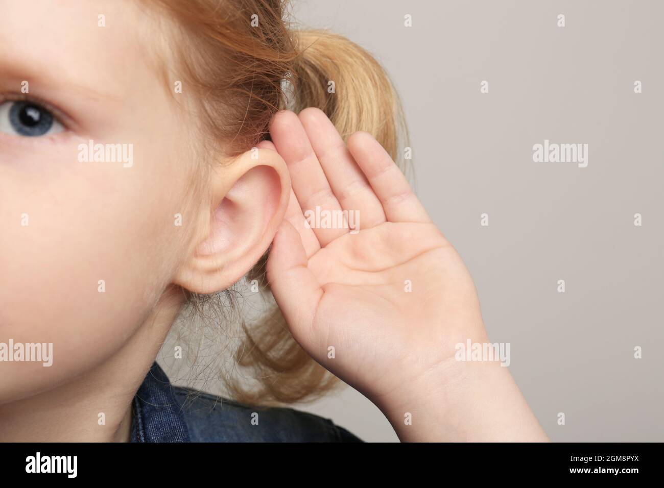 Cute little girl with hearing problem on grey background Stock Photo ...