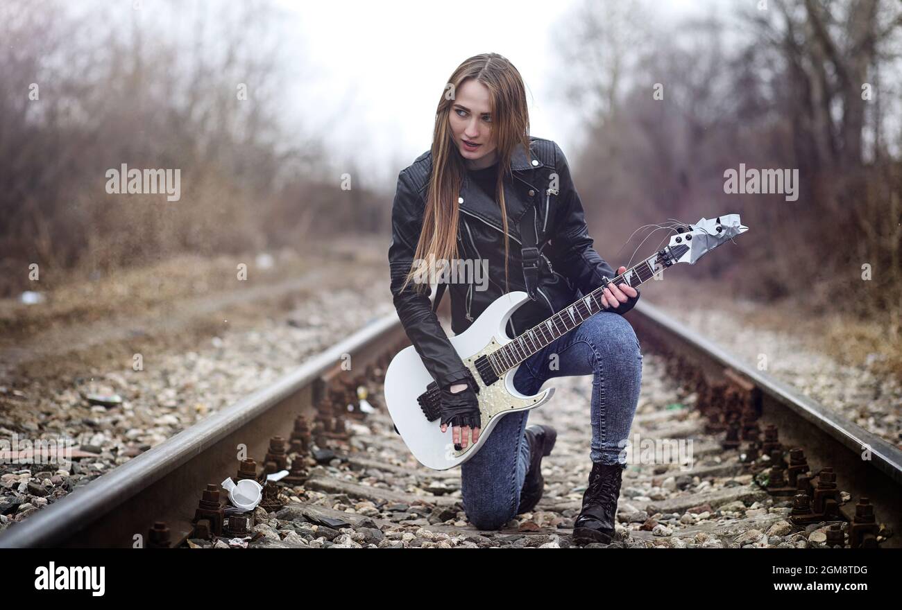 Beautiful young girl rocker with electric guitar. A rock musician girl ...