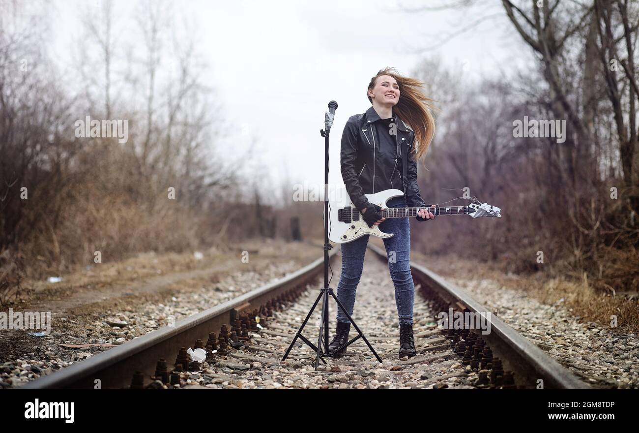 Beautiful young girl rocker with electric guitar. A rock musician girl ...