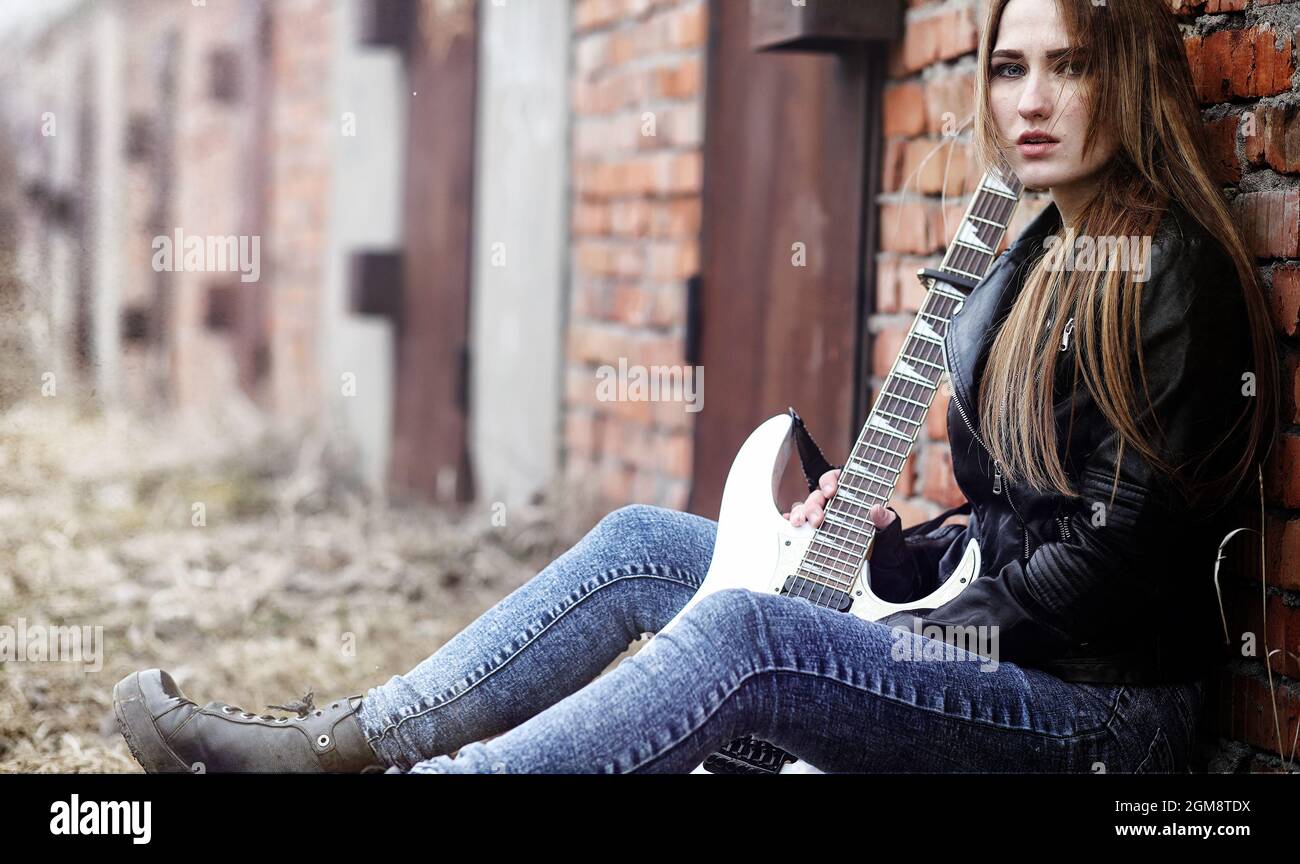 Beautiful young girl rocker with electric guitar. A rock musician girl ...