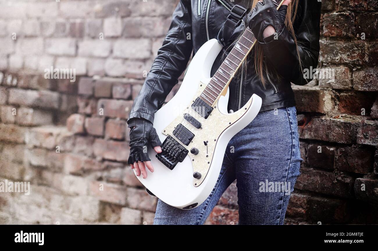 Beautiful young girl rocker with electric guitar. A rock musician girl ...