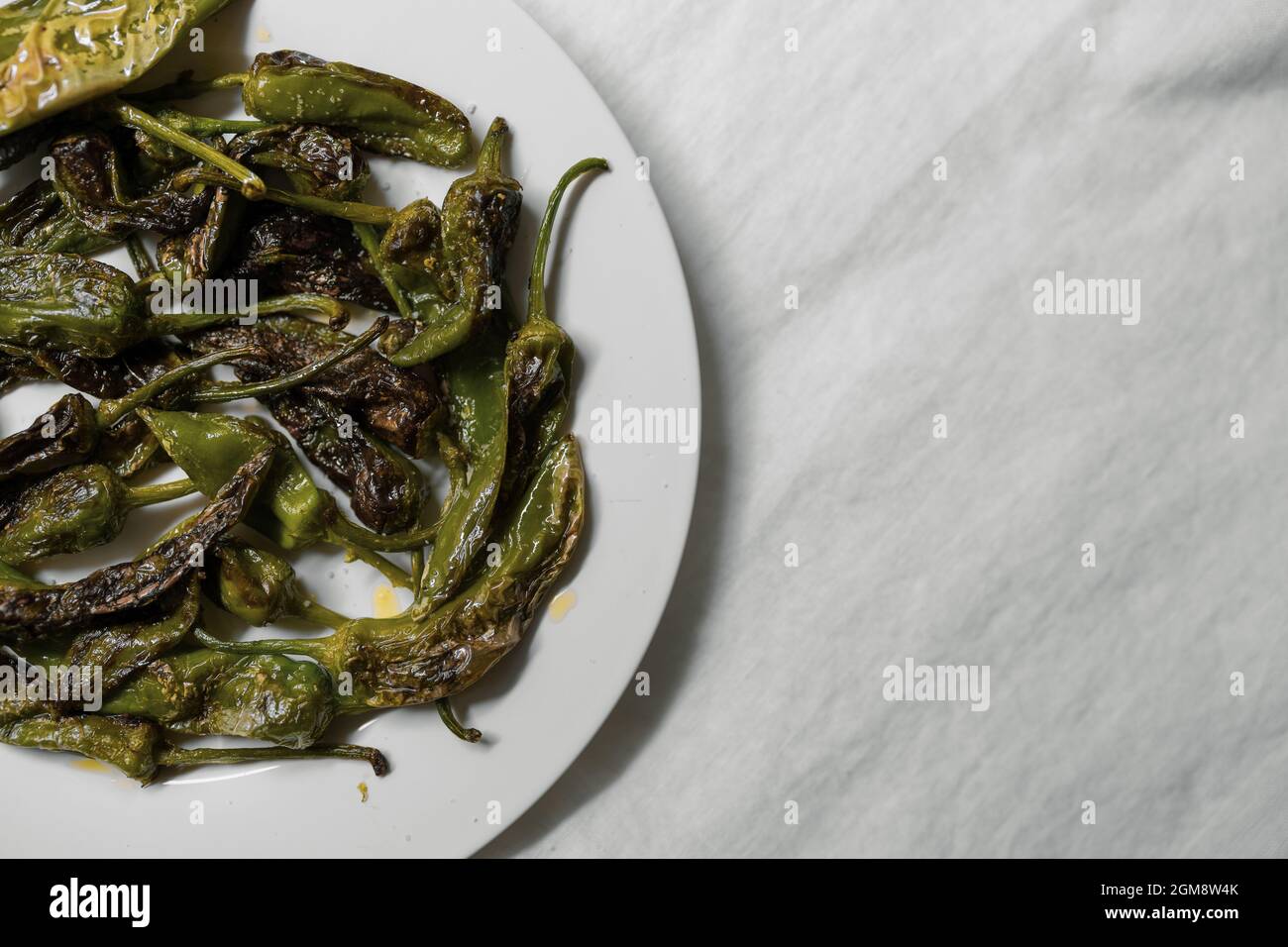 Serving of fried Padron peppers on a white backgroun Stock Photo - Alamy