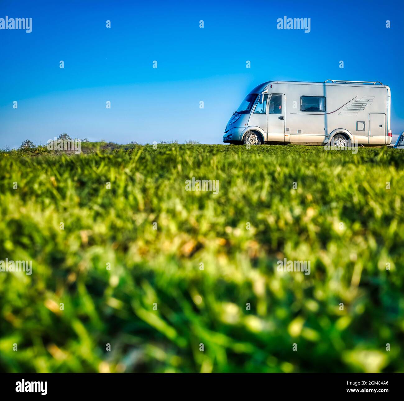 White camper van parked on a green field of grass Stock Photo - Alamy
