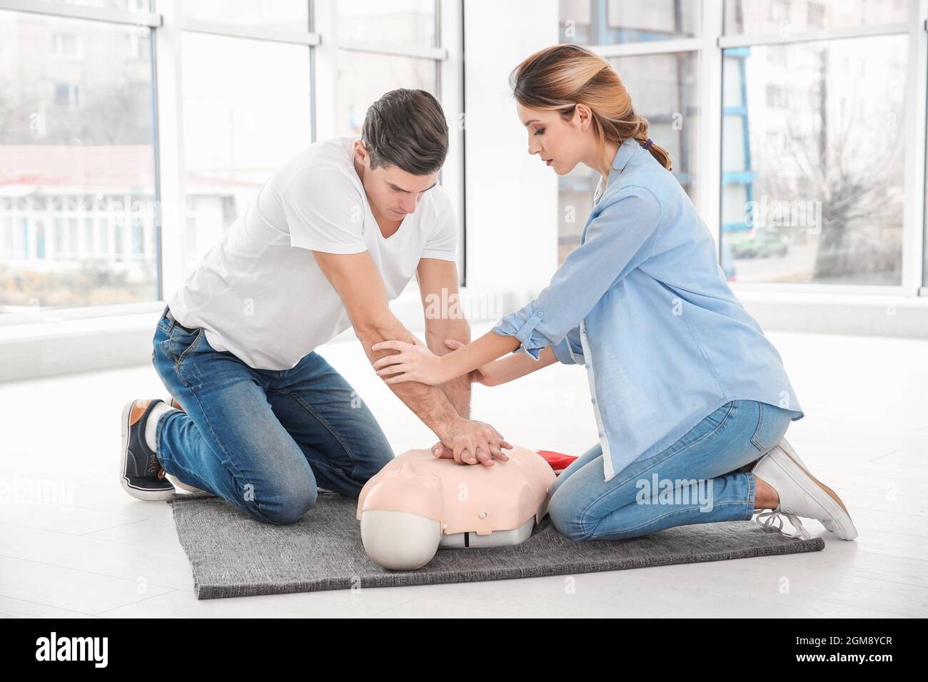 Young man practicing CPR on mannequin in first aid class Stock Photo ...