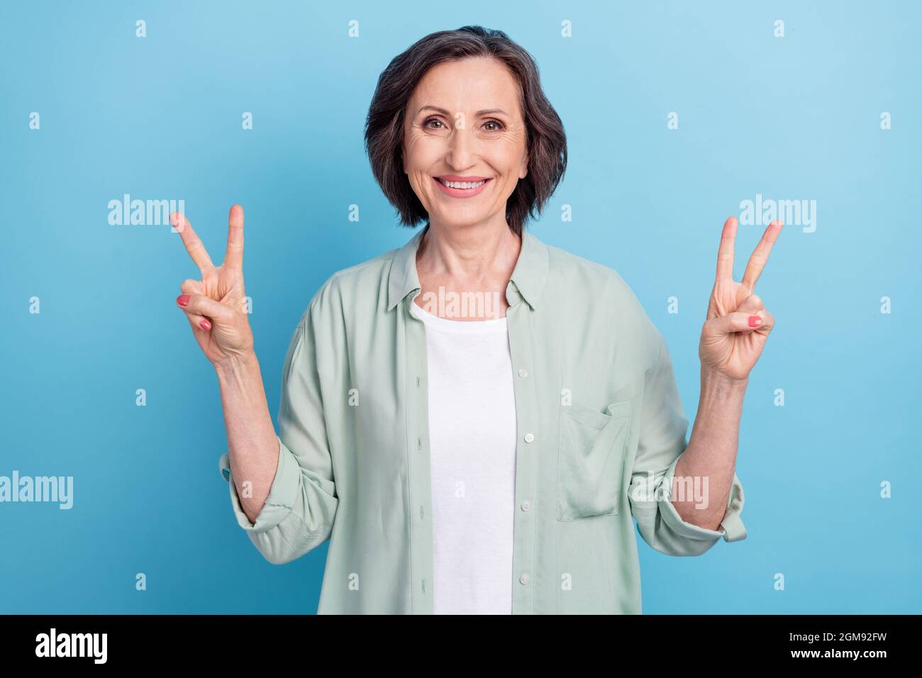 Photo portrait senior woman showing v-sign gesture smiling isolated ...