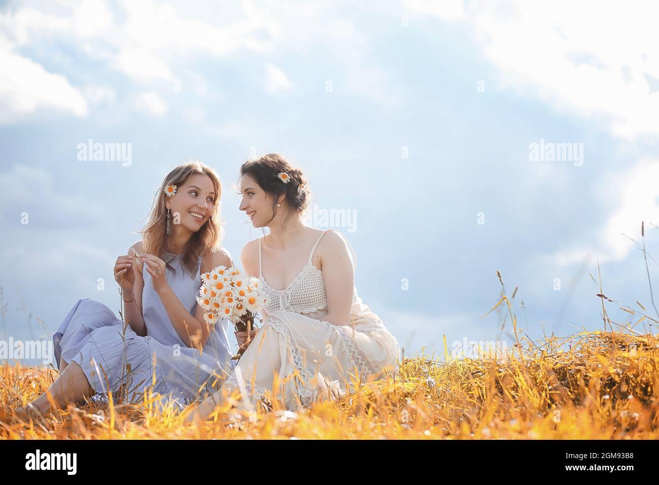 Two beautiful girls in dresses in autumn field have fun Stock Photo - Alamy